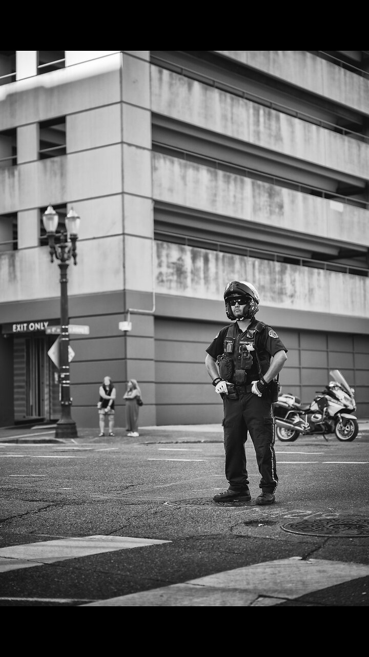 Woman and policeman looking at men in line-up through glass in precinct ...