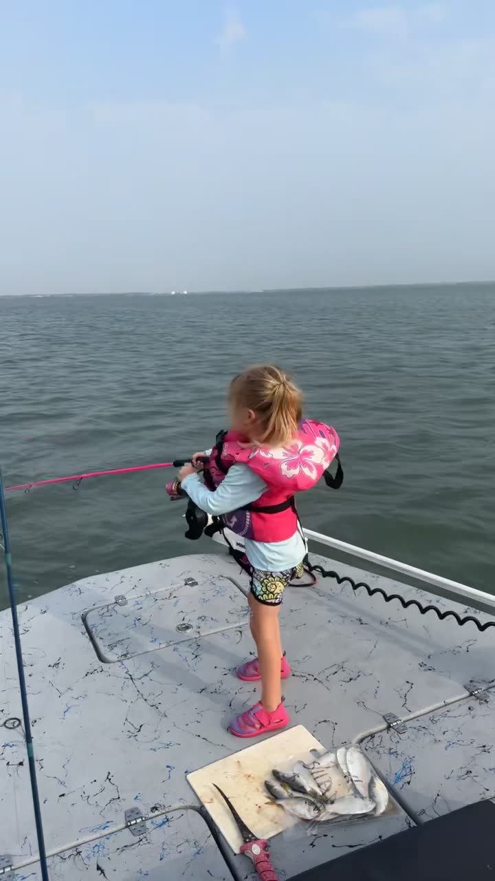 Girl Holds on Tight While Reeling in Fish
