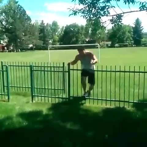 Guy jumps over metal gate and gets foot stuck on top of gate